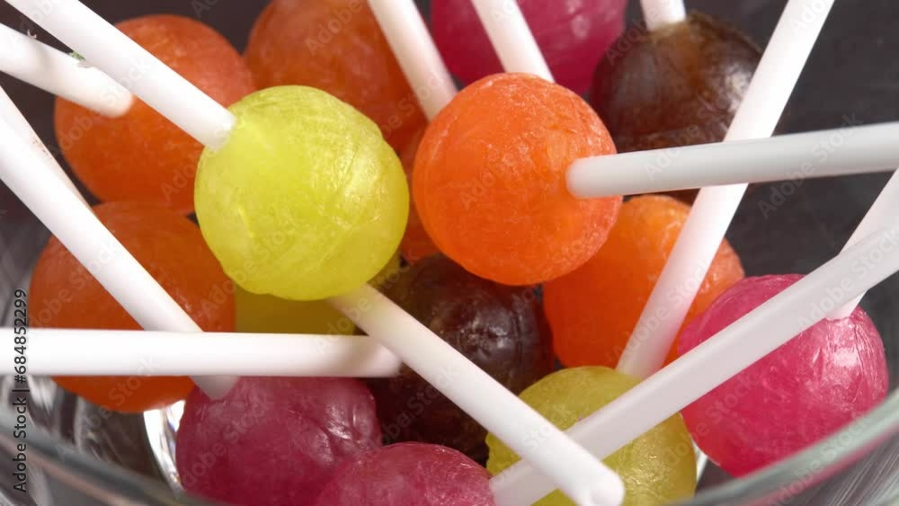 Vidéo Stock Colorful lollipops or candy bonbons on a stick rotate in ...