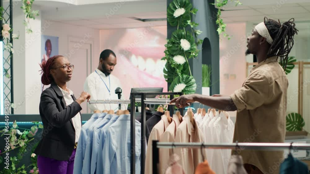 Retail worker in clothing store using augmented reality technology to ...