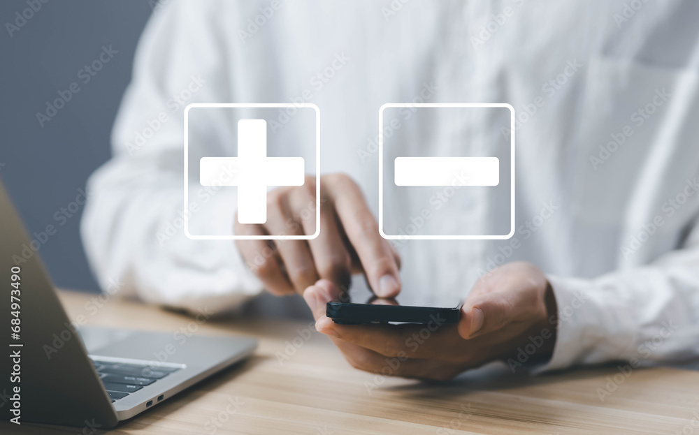 using a smartphone shows icons plus and minus. sign opposite negative ...