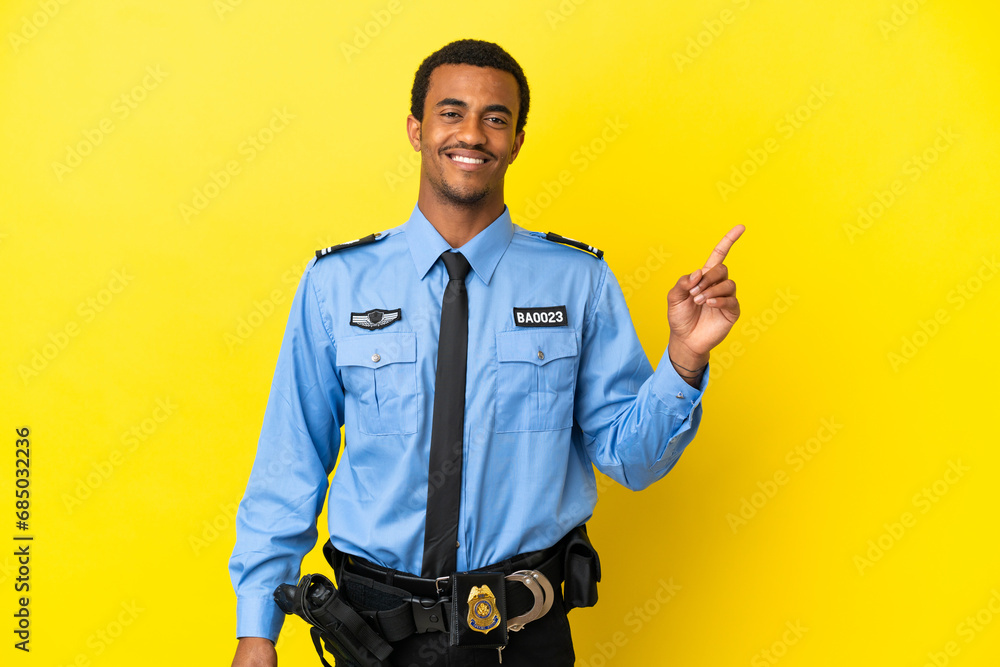 African American police man over isolated yellow background showing and ...