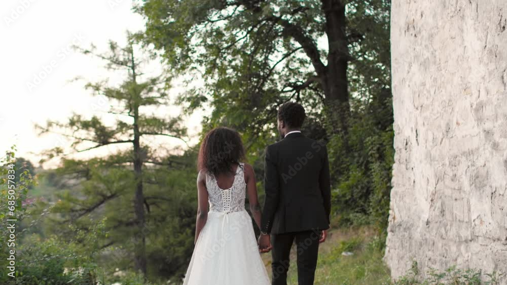 Back view of married young African American couple holding hands while ...