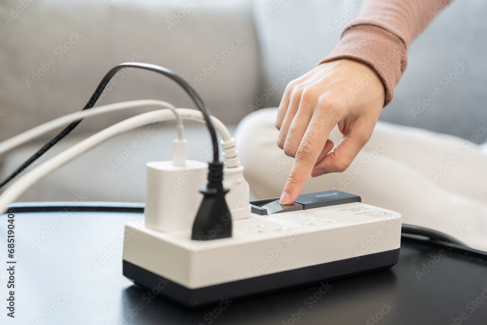 Closed up hand of woman turn off button on switch plug socket for ...
