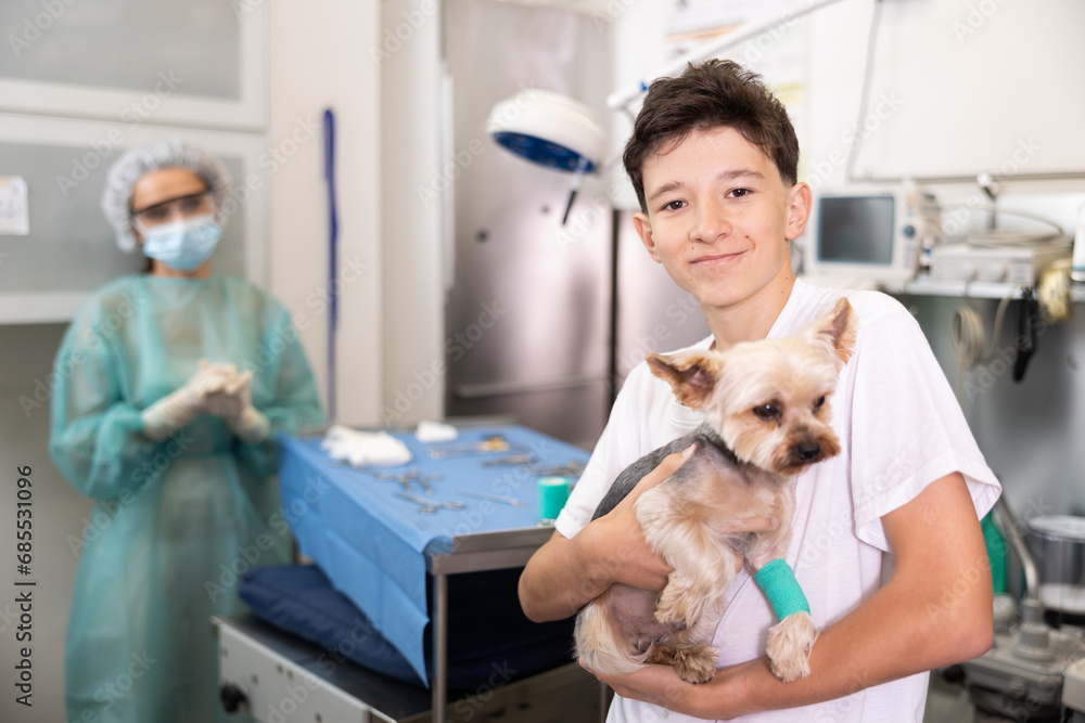 Boy visitors veterinary clinic, happy teenage guy holding Yorkshire ...