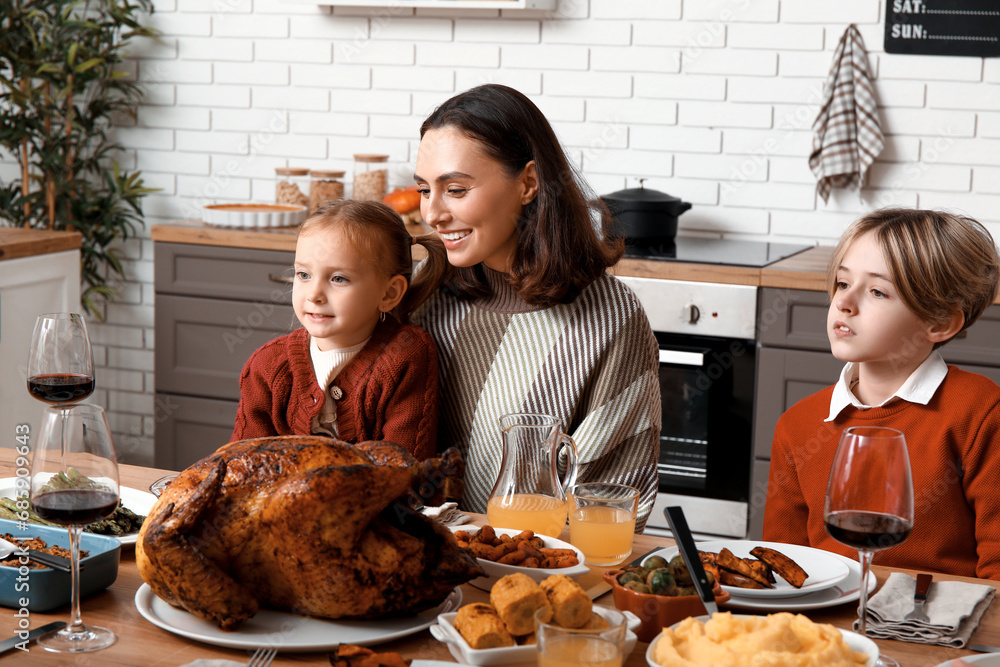 Happy mother with her little children having dinner at festive table on ...