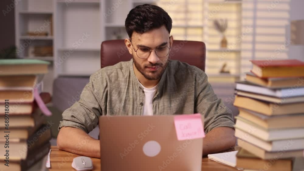 Vidéo Stock Focused motivated young handsome man student with stack of ...