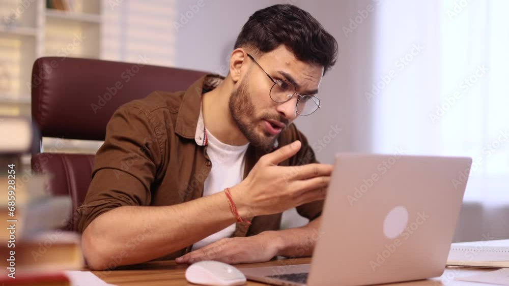Arguing young man looking at laptop screen yelling sitting at home ...
