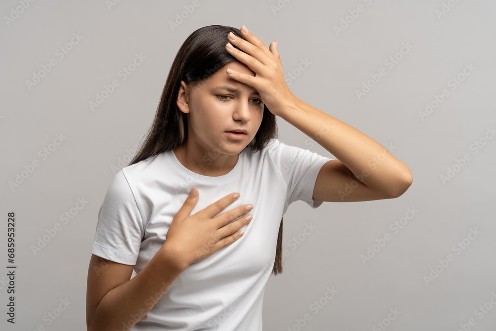 Teen girl feeling headache nausea touching chest forehead isolated on ...
