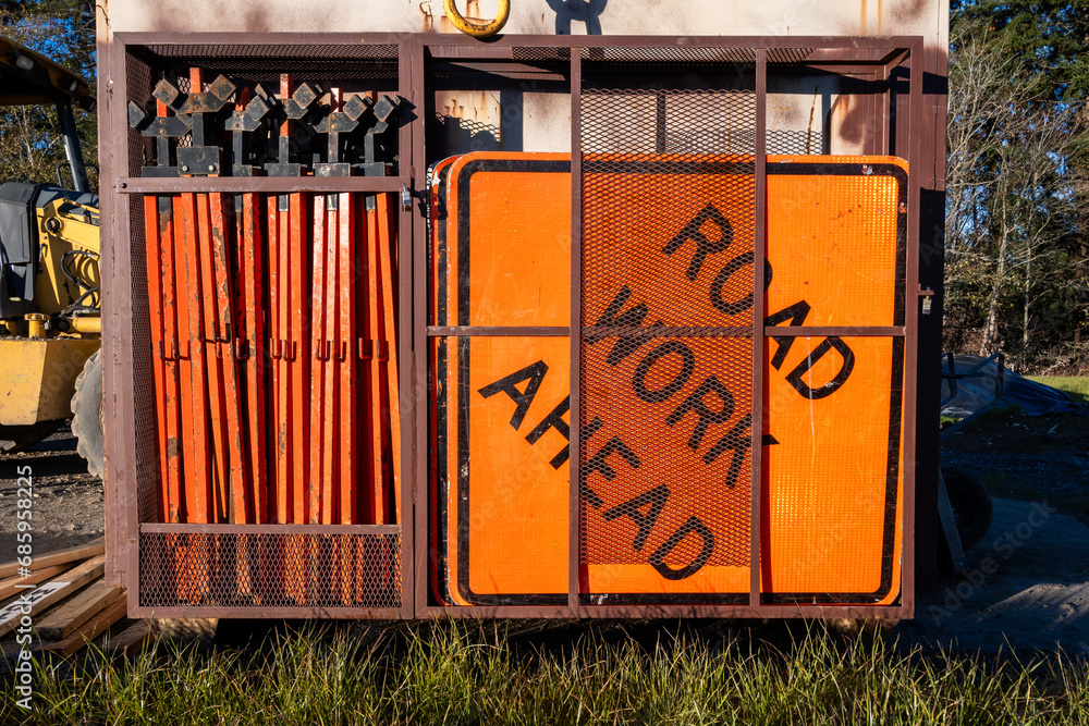Construction supply trailer with stack of Road Work Ahead bright orange ...
