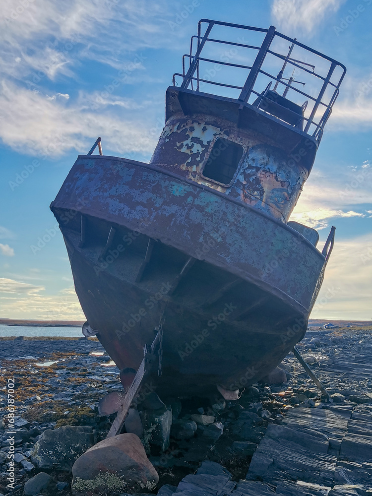 An old fishing schooner, stranded. The old ship is covered with rust ...