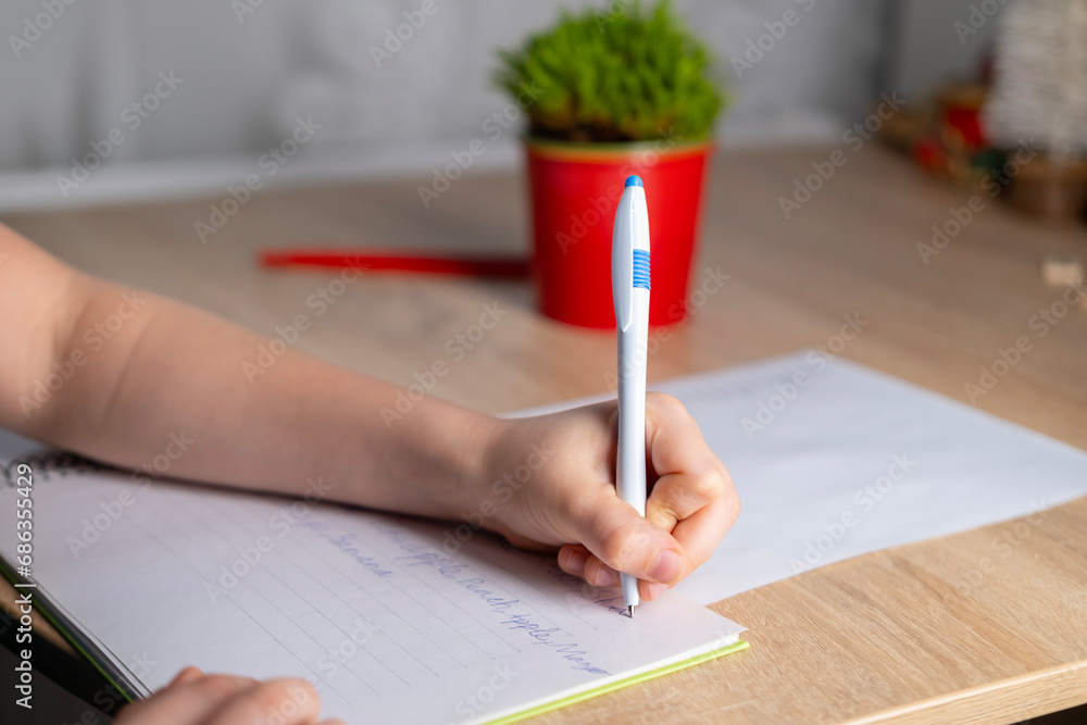 schoolchild doing homework, copying words English, child writes in ...