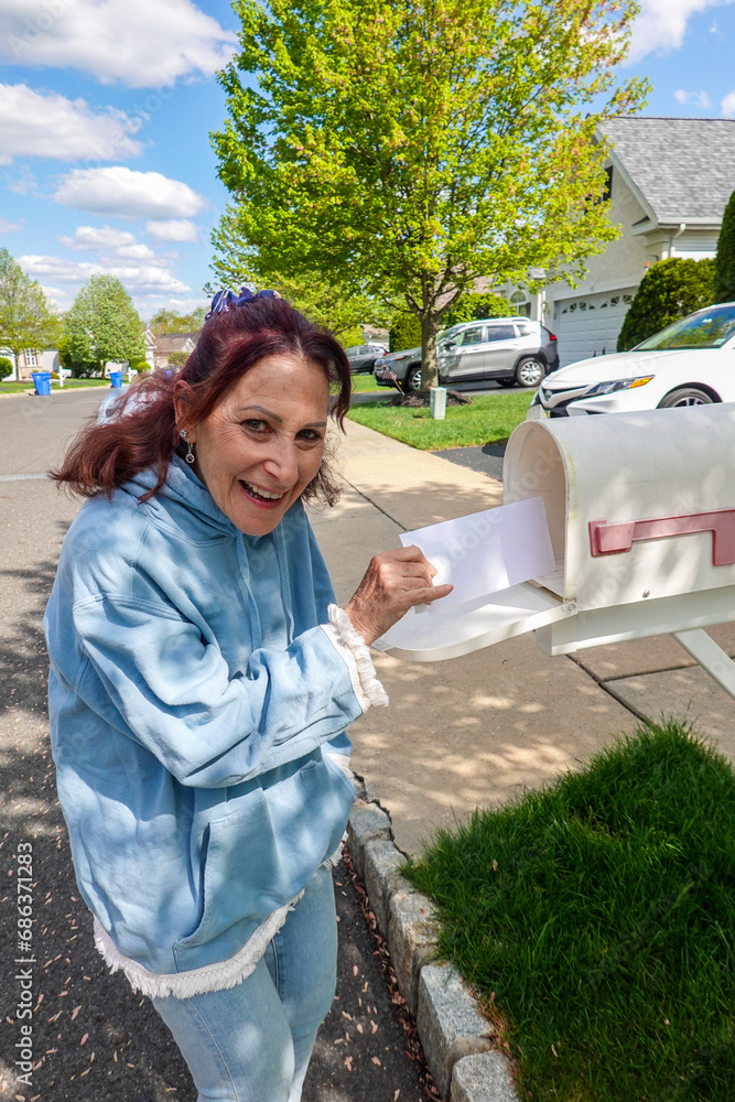 Happy older senior citizen woman smiles as she removes a blank white ...