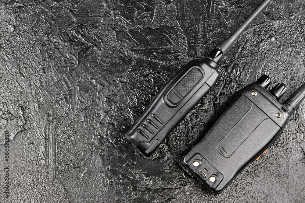 Pair of portable radio station on black graphite background, walkie ...