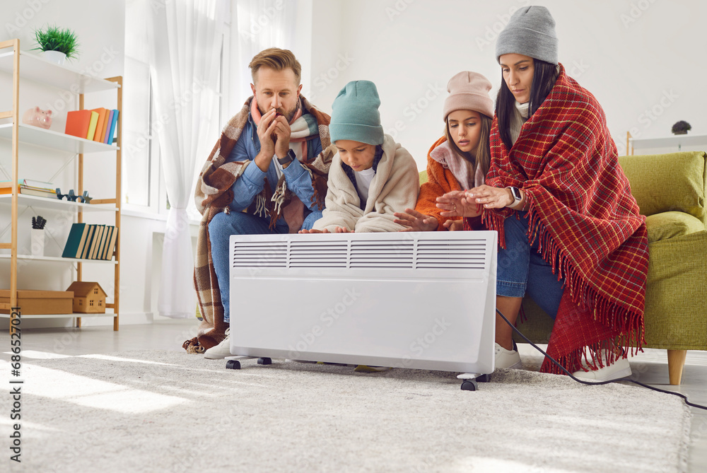 Family getting very cold at home. Sad mom, dad and children wearing ...