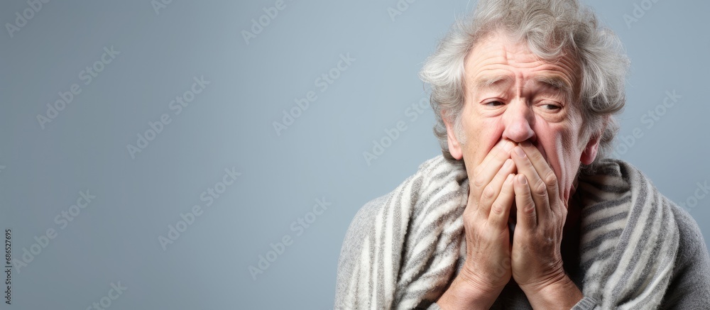 Elderly man in pajamas grimacing while holding his breath and covering ...