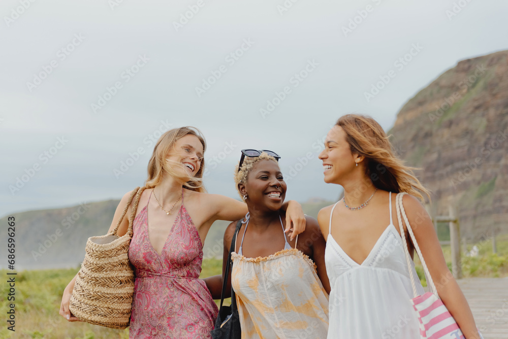Multiracial group of female friends taking a joyful stroll and having a ...