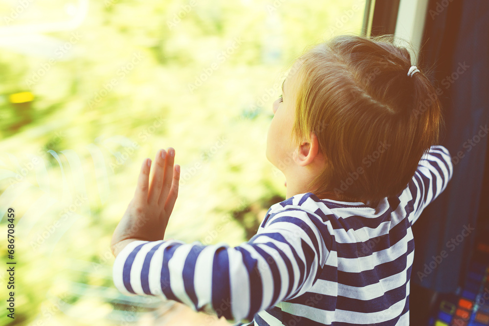Sad child looking out the train window. Kid travels on a train. Little ...