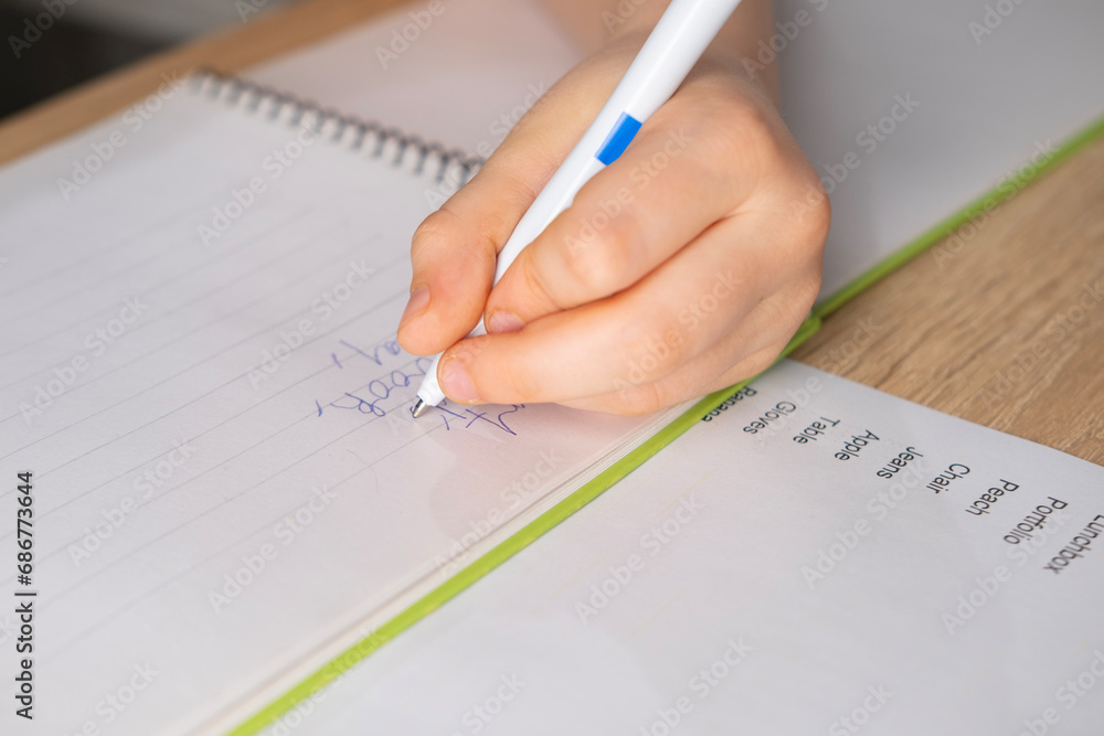 schoolchild doing homework, copying words English, child writes in ...