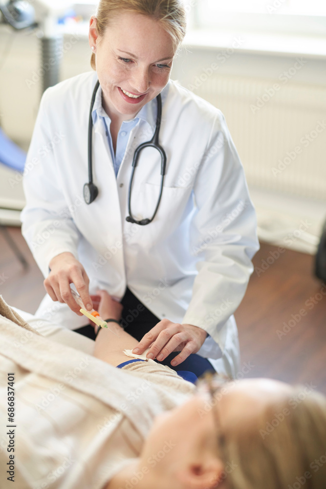 Female doctor taking a blood sample from patient in medical practice ...