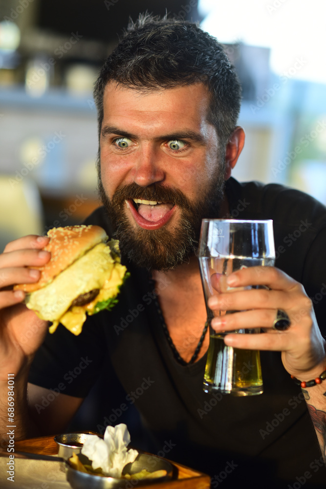 Hunger Man eat burger drink beer. Man eat tasty Hamburger. Dinner with ...