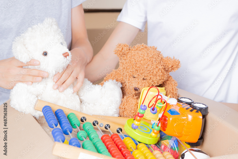 Young volunteer collecting donation box with clothes, school supplies ...