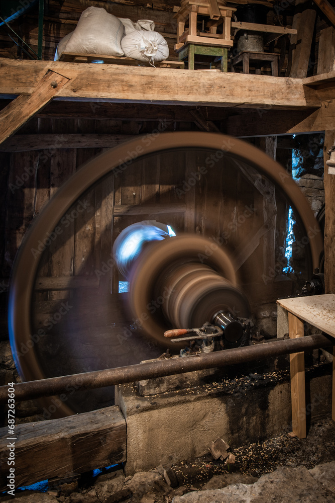 Old functional wooden water mill wheel. Grinding grain into flour in ...