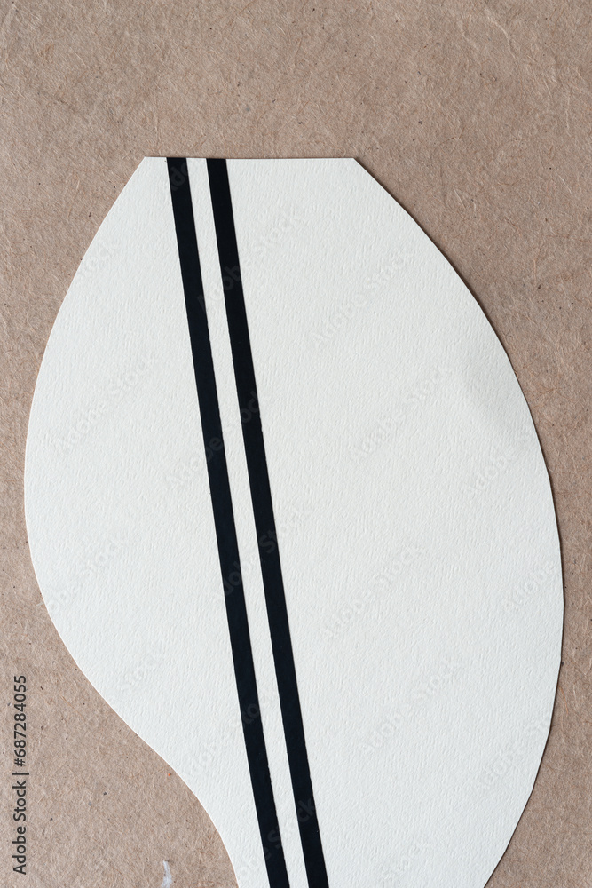 part of a rounded paper shape with parallel lines on plain brown paper ...