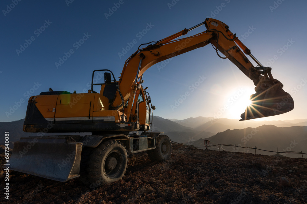 Excavator on the hill at sunset. Excavators are heavy construction ...