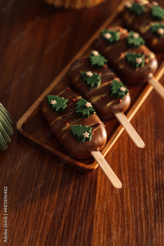 Popsicle-shaped cake on a stick in chocolate with small chocolate trees ...