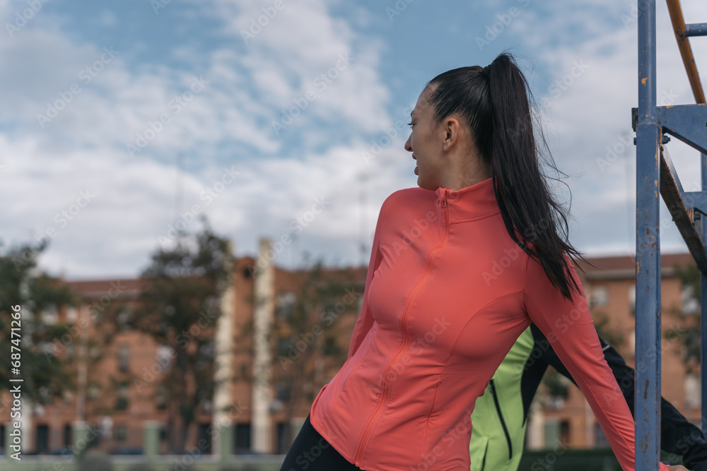 Young female athlete stretching quadriceps femoris on the running track ...