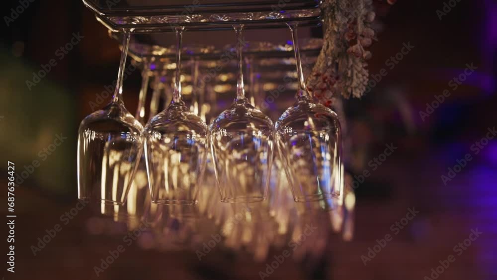 empty glasses hang over the bar counter. view of wine glasses hanging ...
