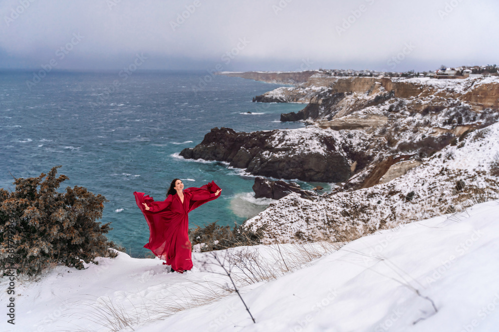 Woman red dress snow sea. Happy woman in a red dress in the snowy ...