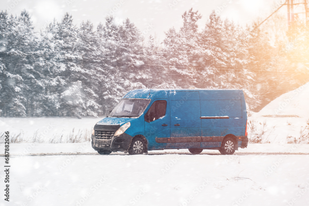 Snowy road challenge for a delivery van. Truck van carrying cargo on a ...