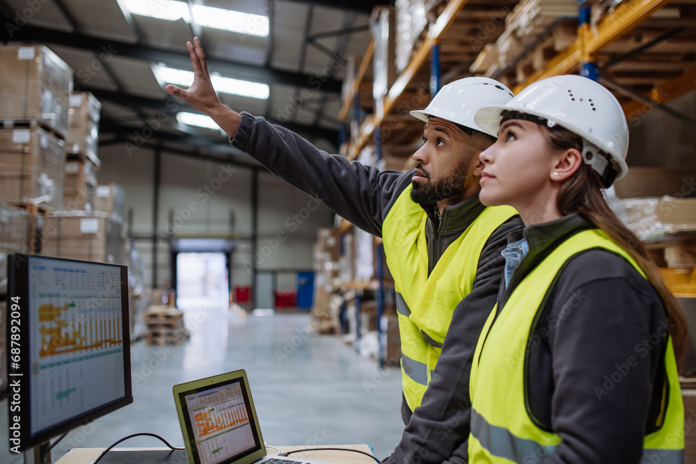 Warehouse manager talking with logistics employee in warehouse ...