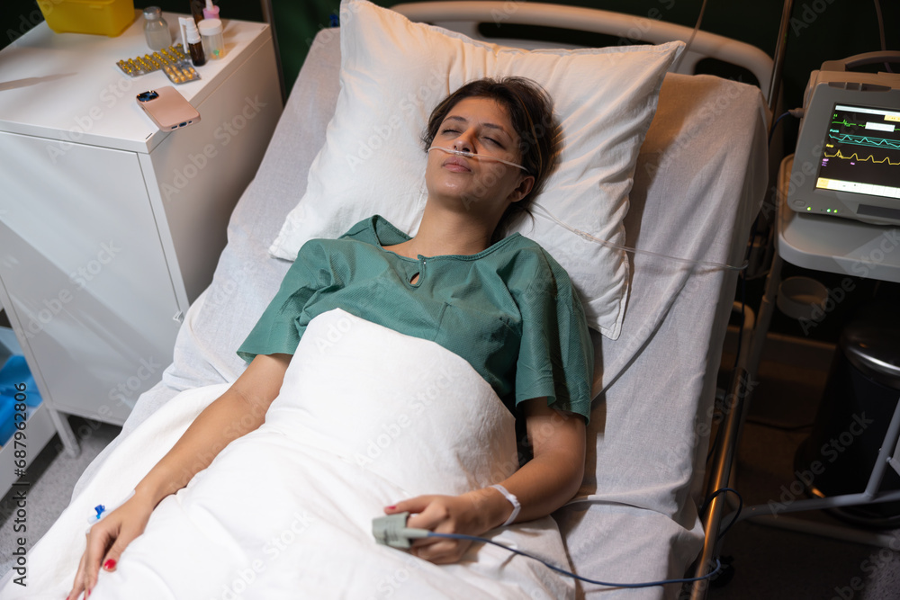 Young woman lies in a hospital bed after a severe accident. She is ...