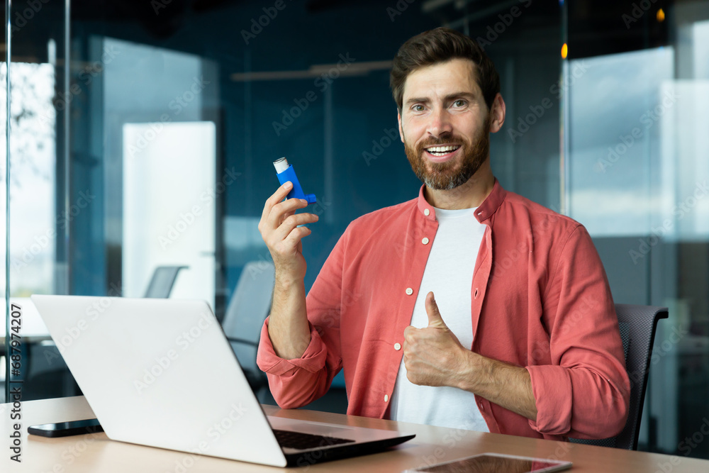 Joyful man with inhaler in hands smiling and looking at camera, showing ...