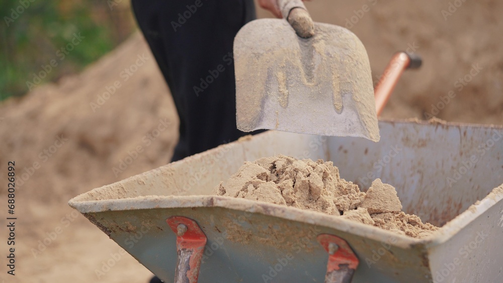 wheelbarrow for transportation of sand close-up. construction workers ...