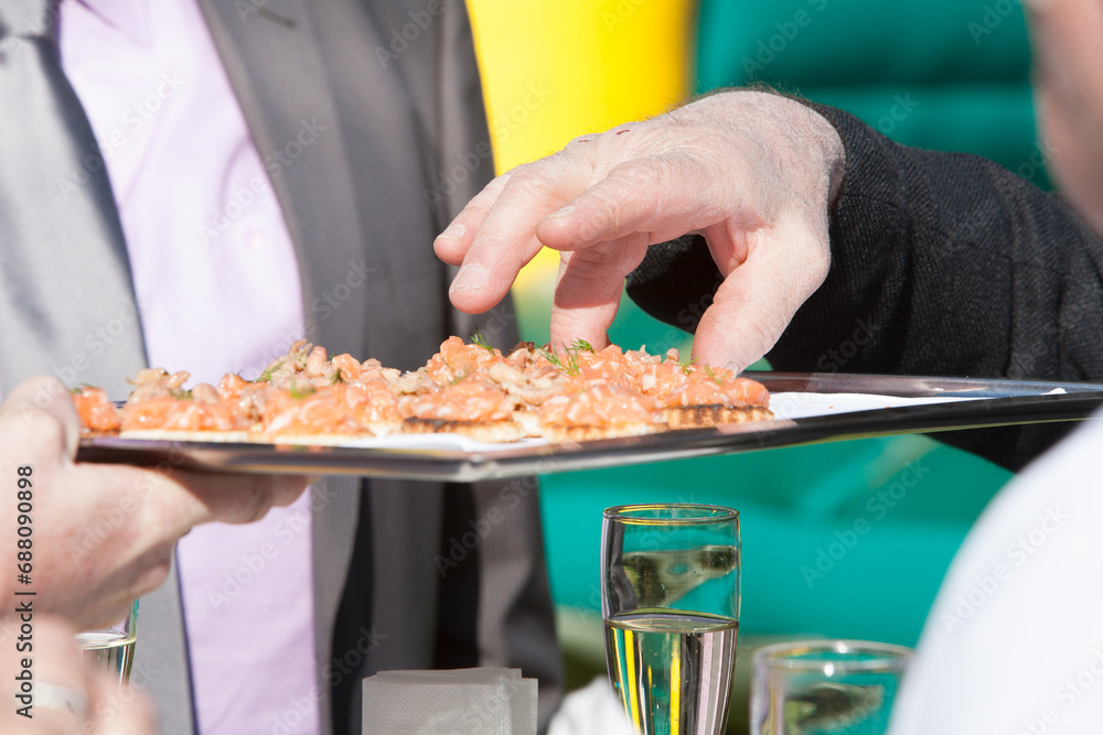 The image captures a moment at a catered event, with a server ...