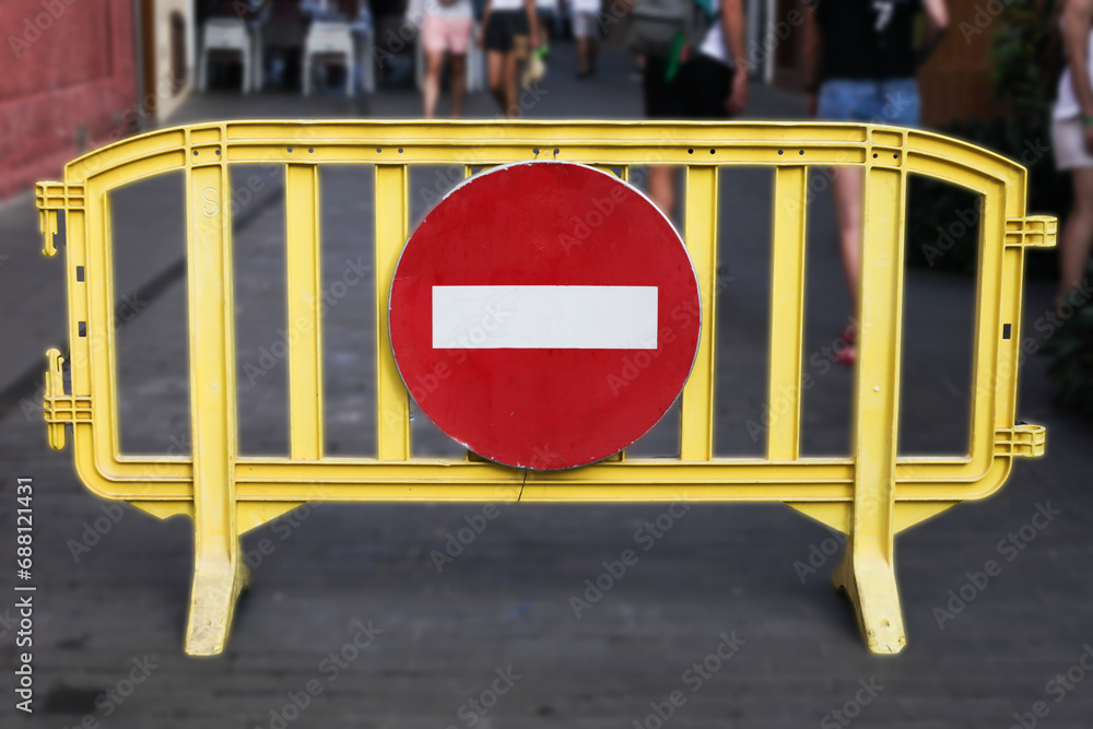 Roadblock yellow fence. Road barrier. Round sign on the road. No entry ...