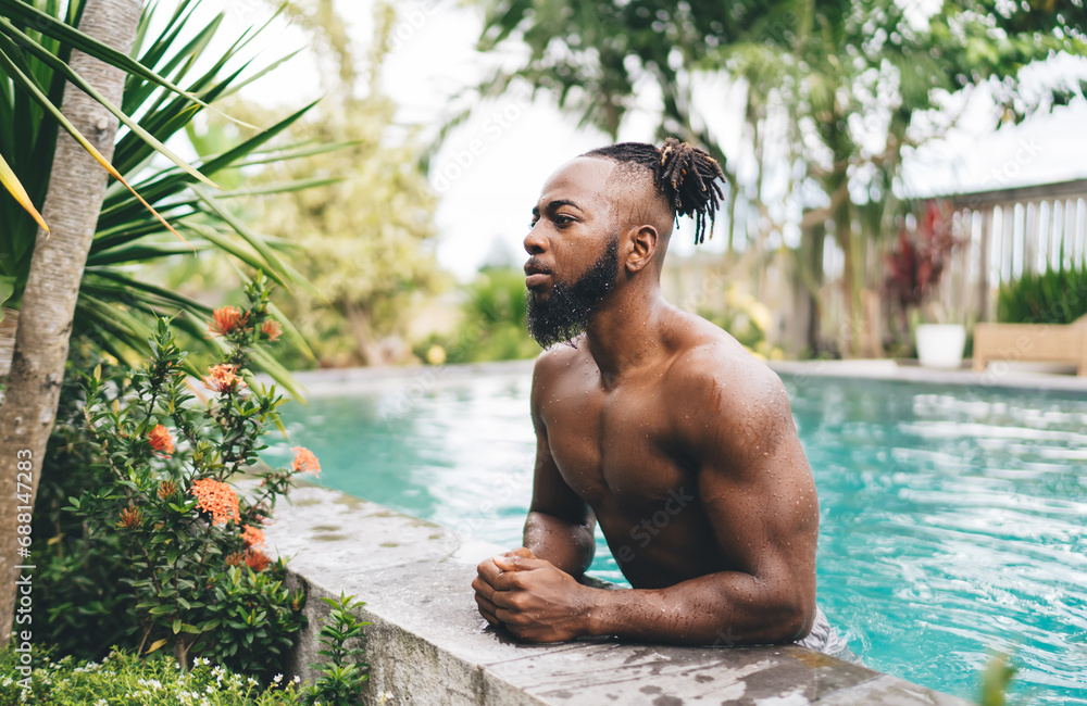 Confident shirtless black man standing in pool while resting hands on ...