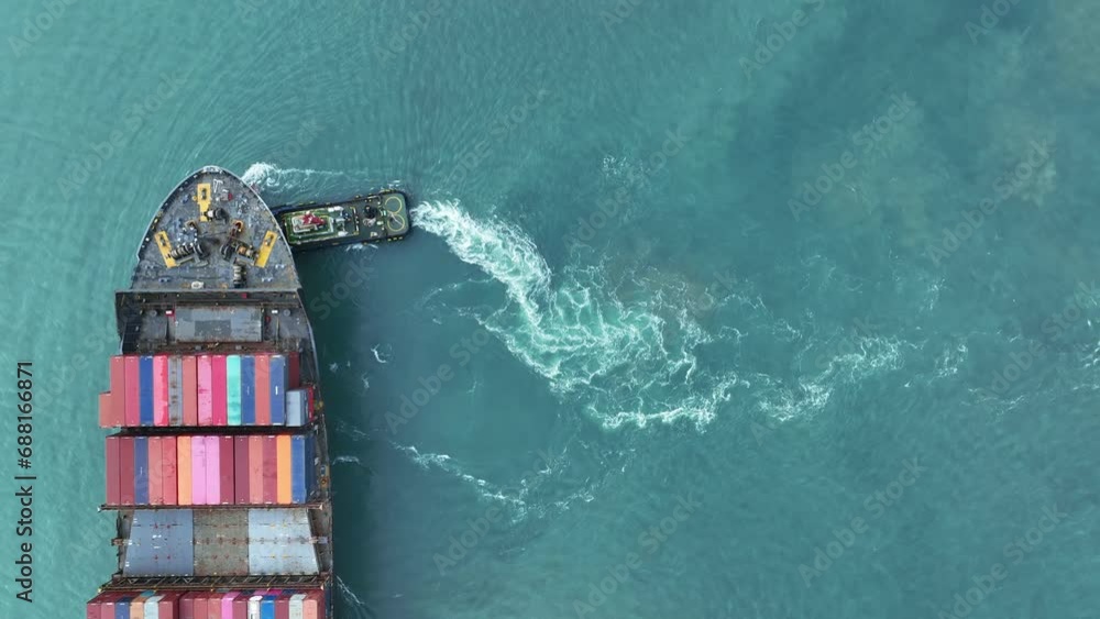 Aerial top view of cargo ship carrying container and pulling by tug ...