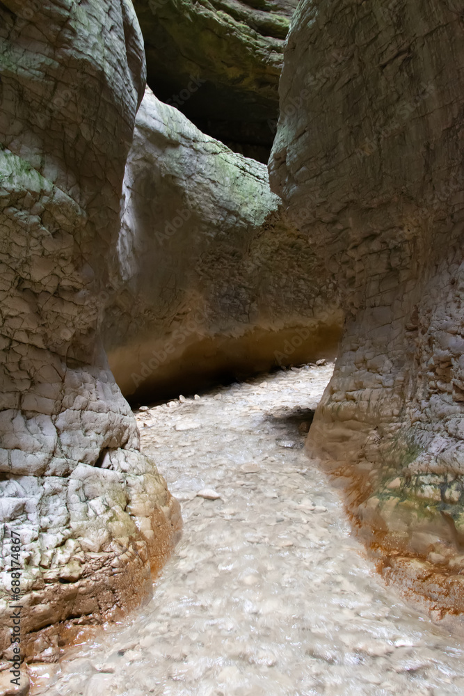 Beautiful curves of rocks in the cave. A ray of sunlight enters the ...