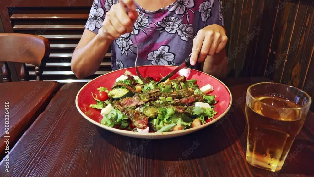 woman eating roast beef meat cooked to perfect medium-rare, with a ...