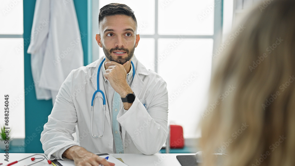 Young hispanic man doctor having medical consultation at the clinic ...