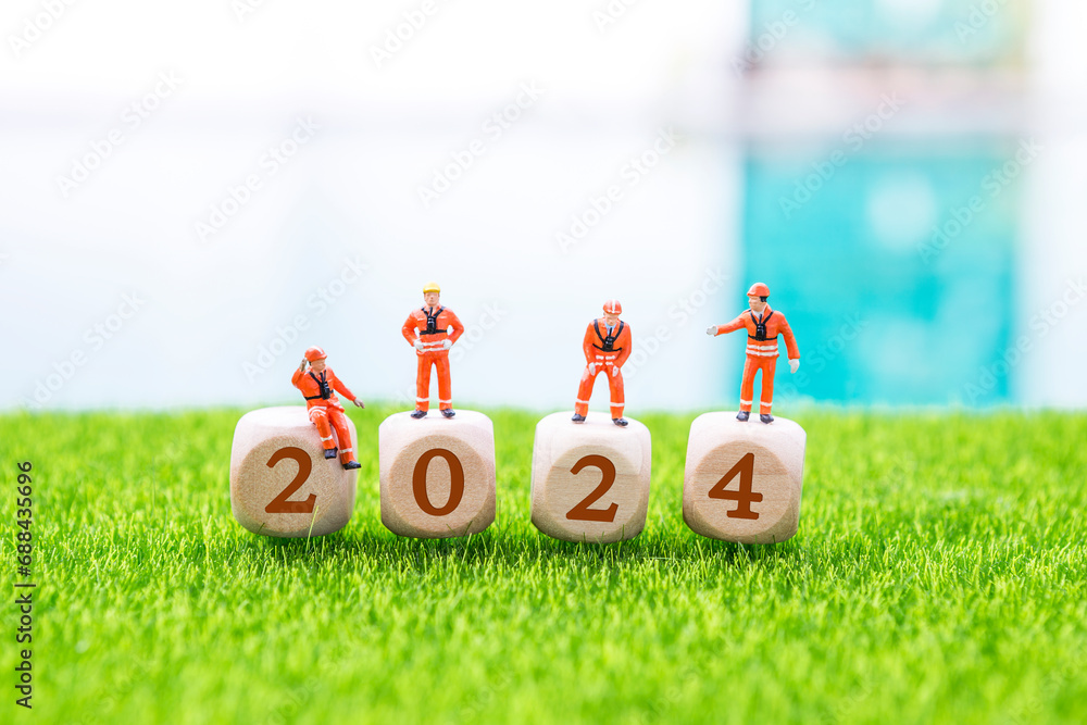 New year 2024 concept, miniature worker on wooden cube with number on ...
