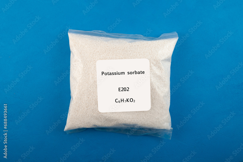 Potassium sorbate in transparent plastic bag on blue background. Food ...