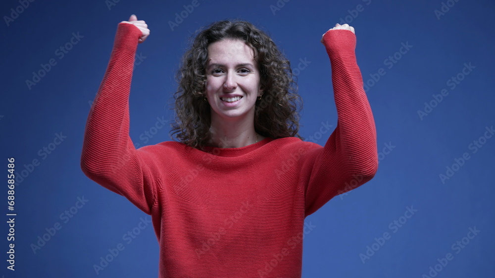 Woman celebrating success by raising fist in the air feeling delight ...