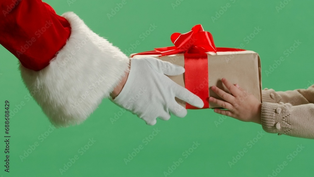 Santa hands handing a gift to a little girl against a green screen ...