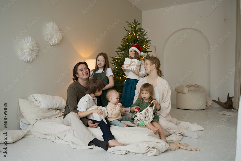 Festive family gathering around a Christmas tree Stock Photo | Adobe Stock
