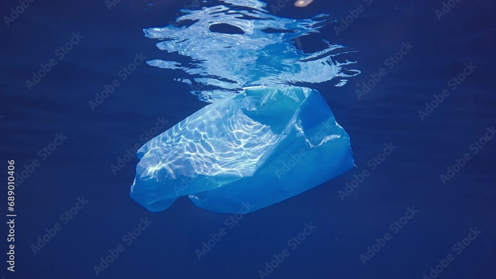 Disposable light blue plastic bag drifts underwater reflecting on ...