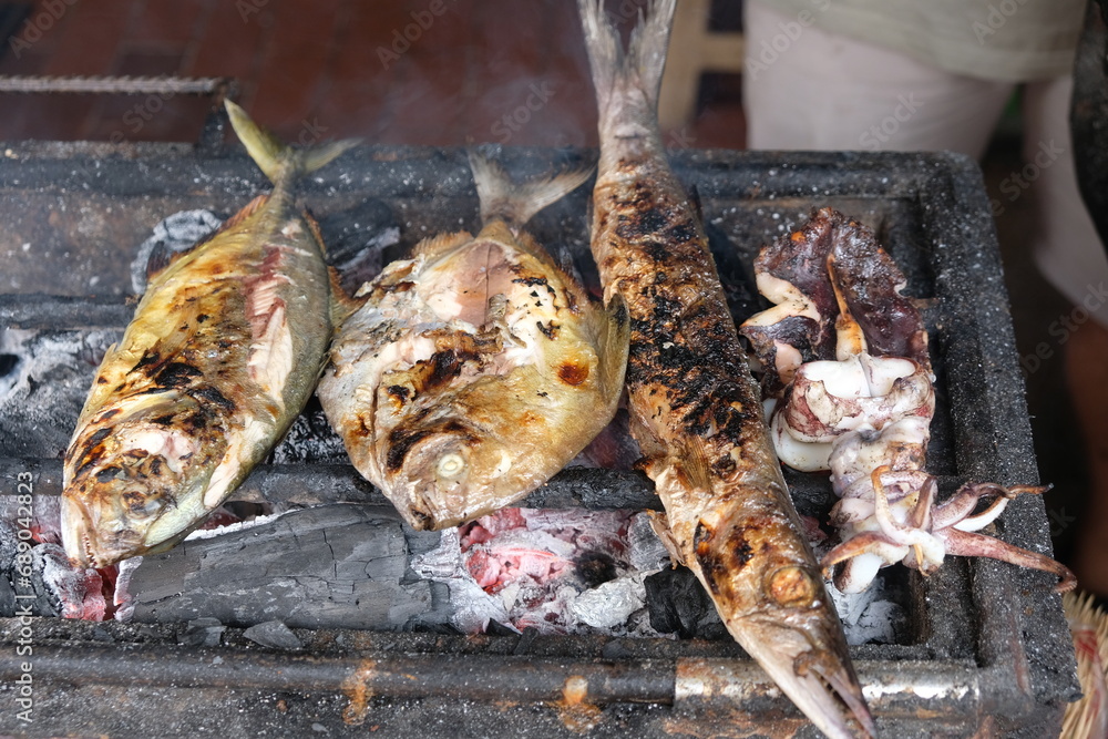 grouper, pomfret, barracuda, squid grilled on a charcoal grill. grilled ...
